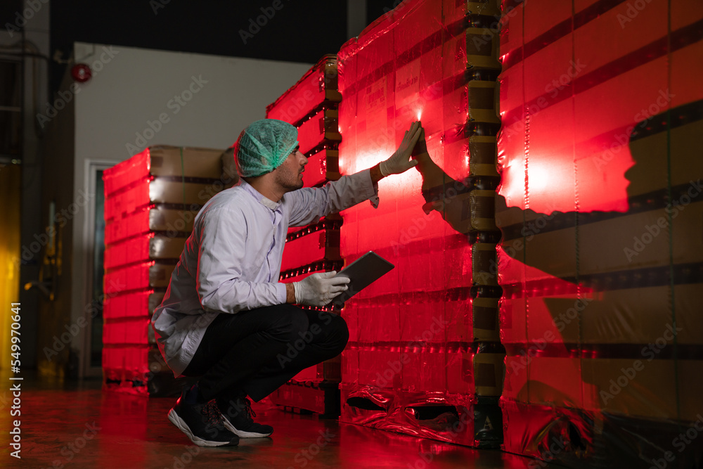 Man worker quality control a fruit drink factory in glass bottles ...