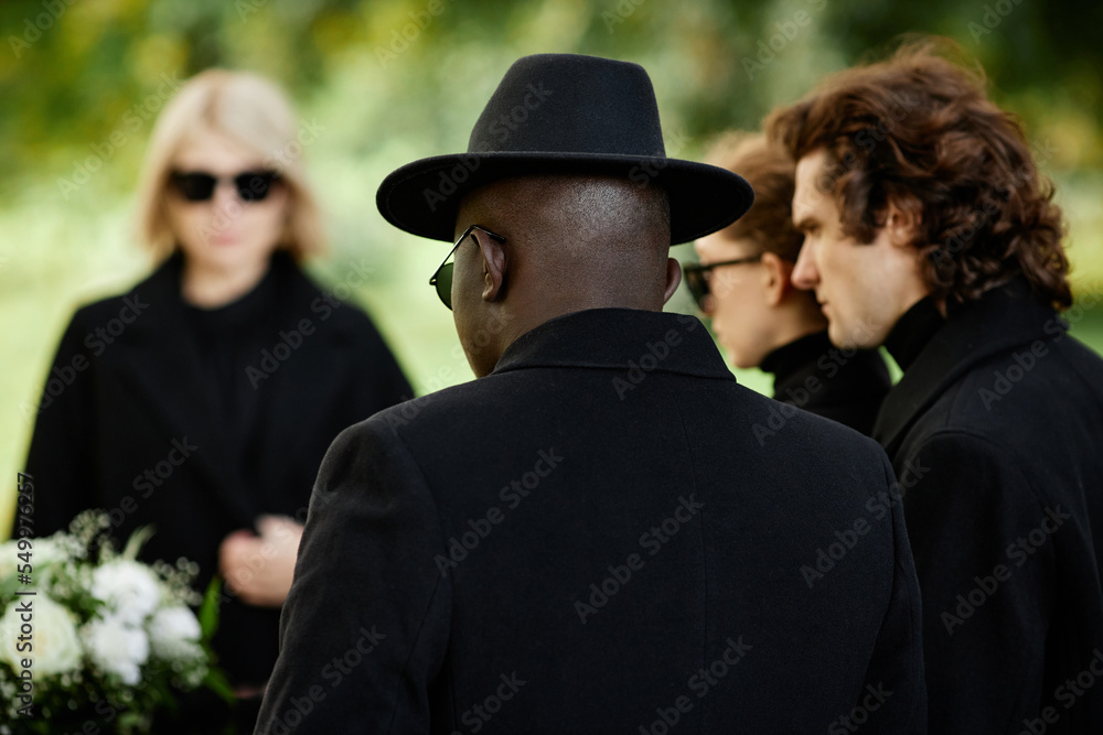 Foto de Back view of man wearing black standing at outdoor funeral ...