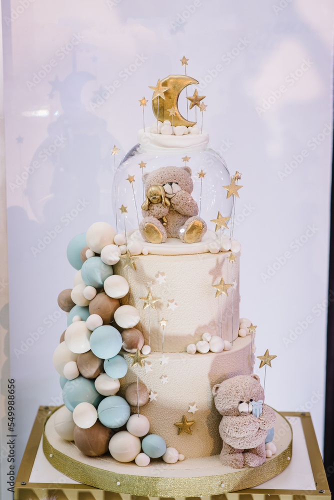 Trendy Cake with a figure bear, moon, and stars for a boy or girl. Tiered cake decorated gold ...
