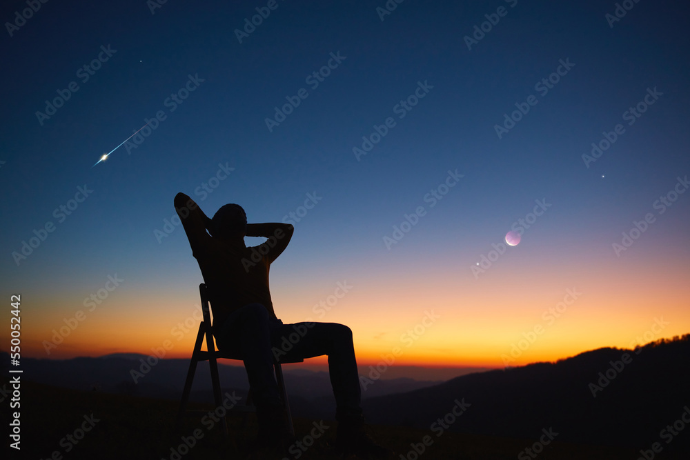 Man looking at the night sky, stars, planets, Moon and shooting stars ...