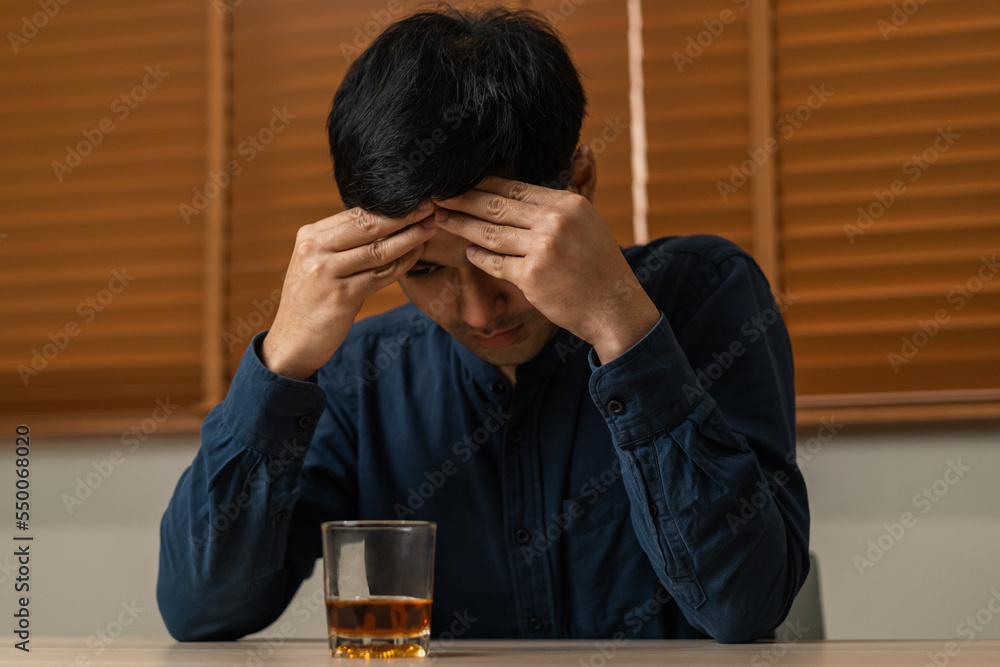 Alcoholism, hand cover face asian young man have headache, drink a ...