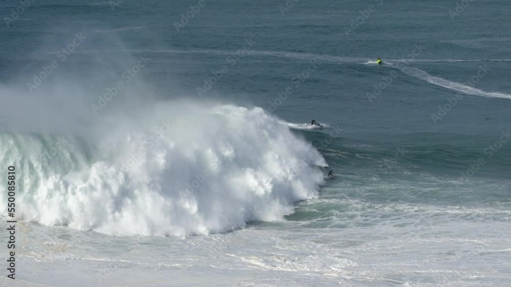 Surfer riding big wave in Nazare, Portugal. Nazare is famously known to ...