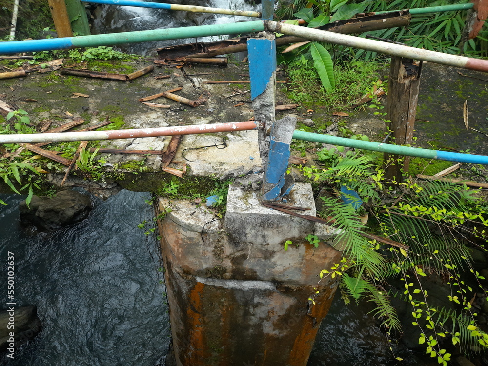 Broken pipe railings on a bridge that is about to collapse overgrown ...