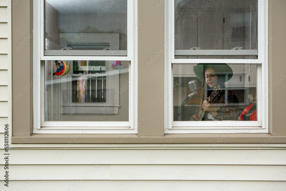 View of musician at window singing with guitar into microphone Stock ...
