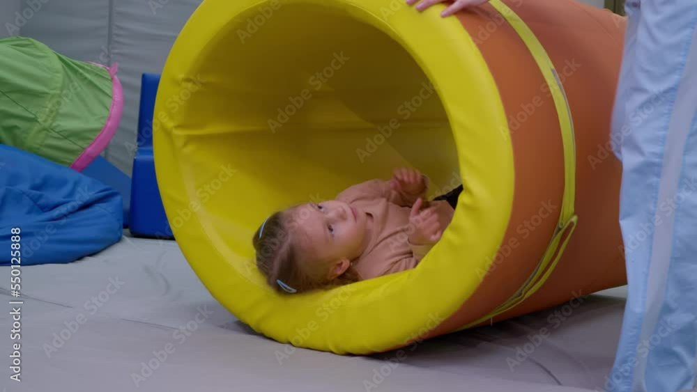 Kid girl rotation in roller tonnel during sensory integration session ...