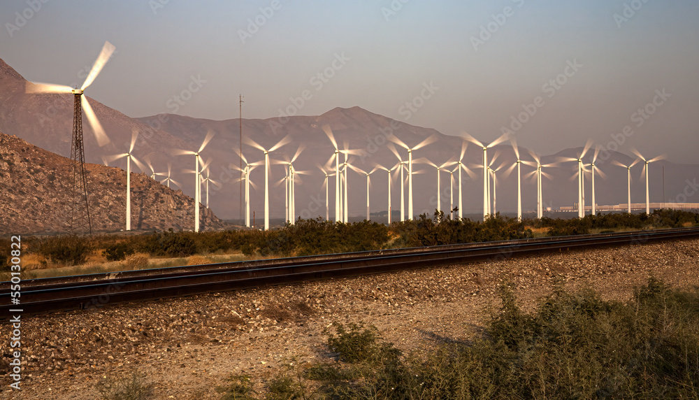 Foto de railroad tracks pass through a windmill farm as turbine tune to ...
