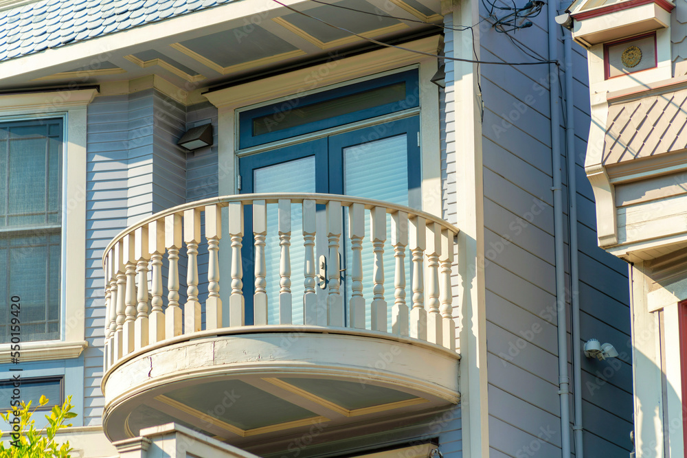 Round white balcony with wooden hand rails and banisters on house with ...