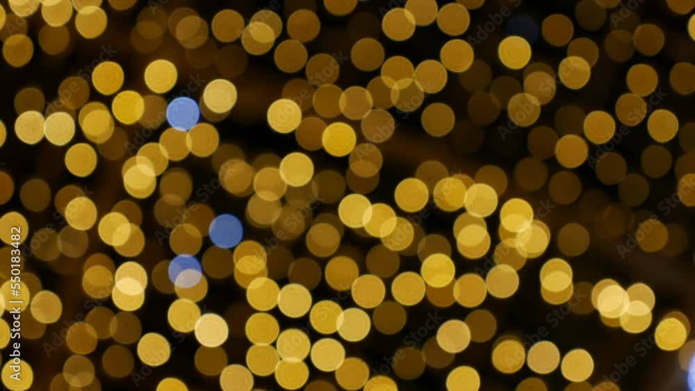 Defocused holiday lights glowing in darkness in night city streets ...