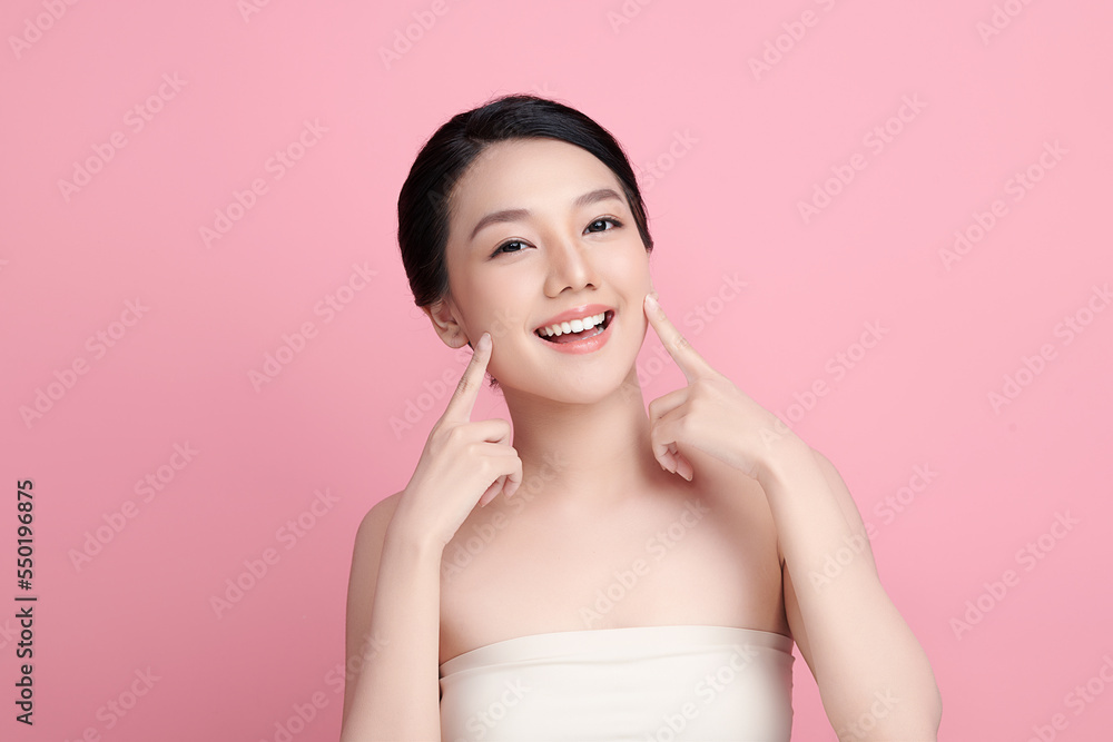 Beautiful young asian woman with clean fresh skin on pink background ...