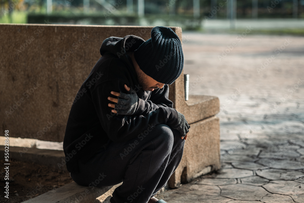 Poor tired stressed depressed hungry homeless man in the shadow city ...