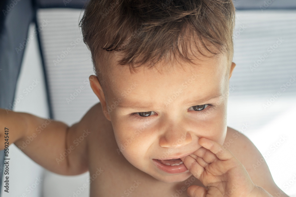 upset dissatisfied angry baby boy child kid in baby crib refuse to stay sleep day time sun light ...