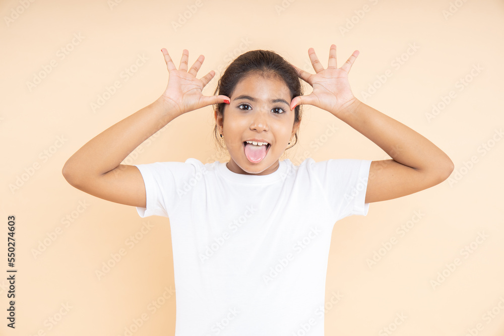 Little indian girl kid wearing plane white t-shirt making faces looking ...