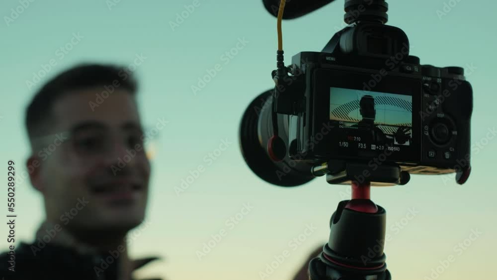 Happy, good-looking male content creator talking to the camera during ...