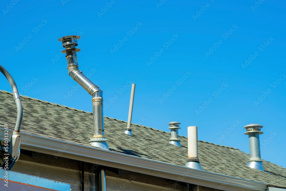 Chimney vents in rows on top of double gable style roof with gray ...