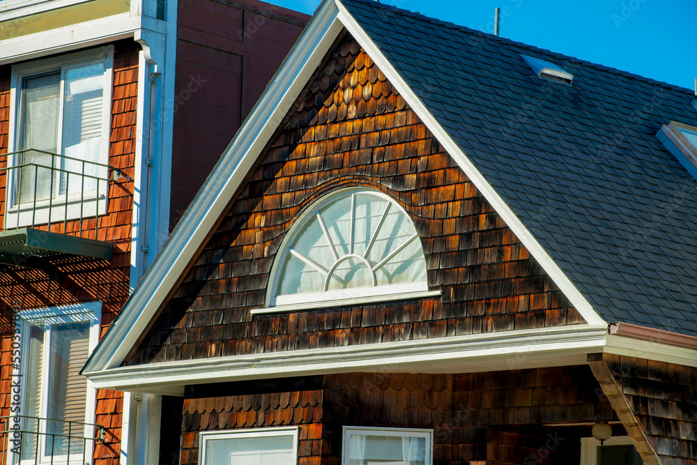 Double gable style roof with gray tiles and aged and weathered exterior ...