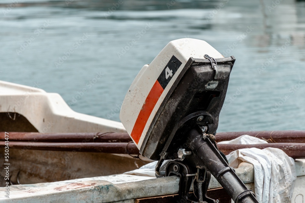 Selective closeup focus of a vintage outboard motor on a boat with the ...