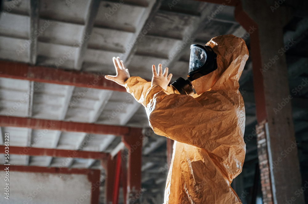 Nuclear explosion. Man dressed in chemical protection suit in the ruins ...