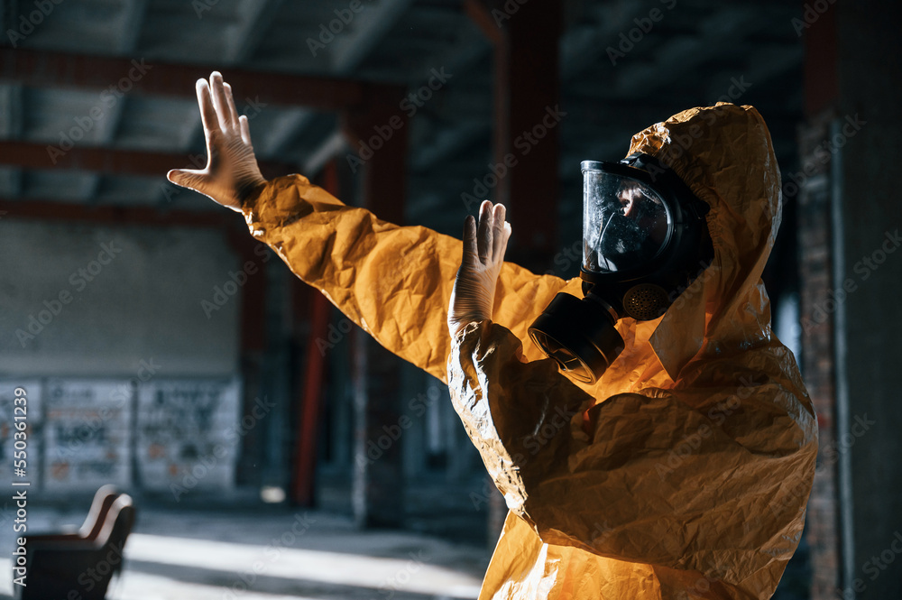 Nuclear explosion. Man dressed in chemical protection suit in the ruins ...