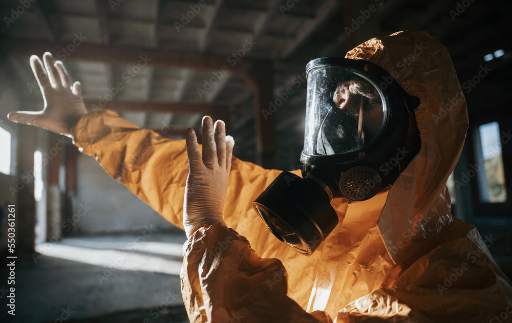 Light from nuclear explosion. Man dressed in chemical protection suit ...