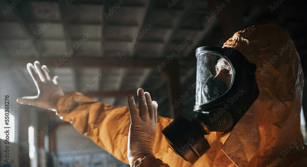 Light from nuclear explosion. Man dressed in chemical protection suit ...