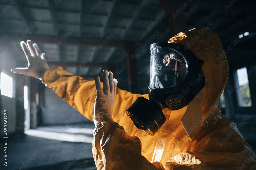 Light from nuclear explosion. Man dressed in chemical protection suit ...