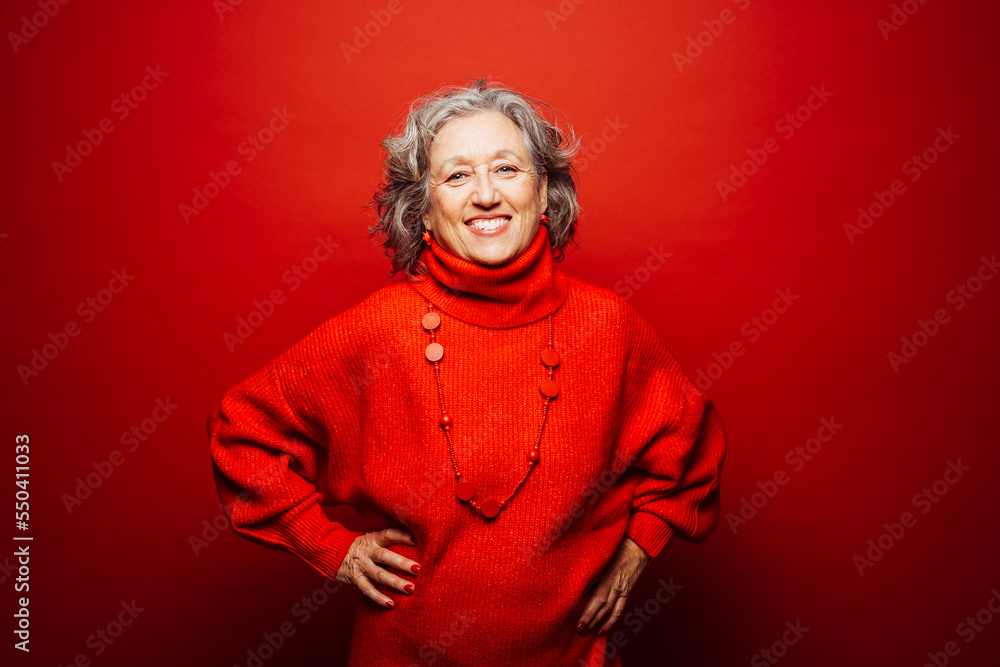 Portrait Of A Senior Smiling Woman Wearing Red Clothes Over A Red