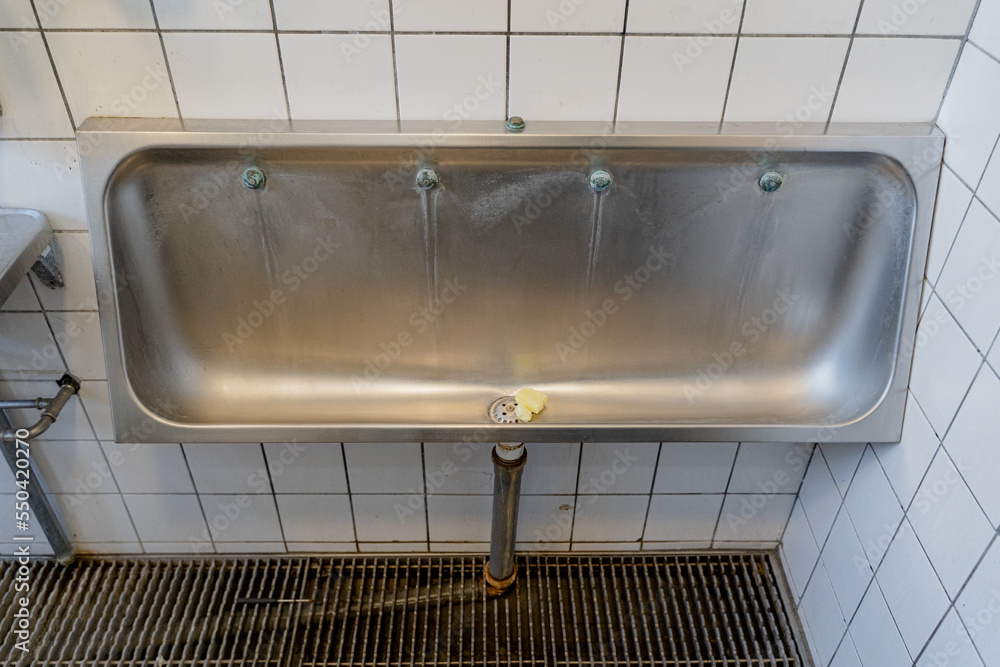 Urinal. Metal urinal in a public toilet. Stock Photo | Adobe Stock