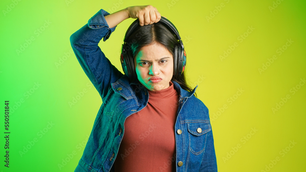 Beautiful young woman listening to music using headphones, Asian Indian ...