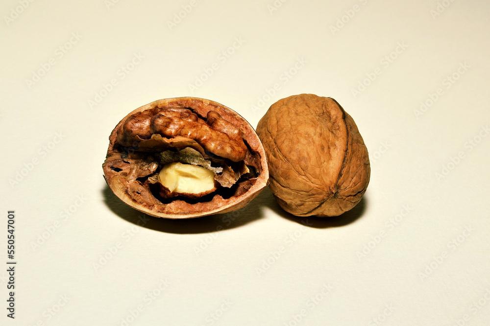 Opened walnut stems next to a whole walnut close-up on a white ...