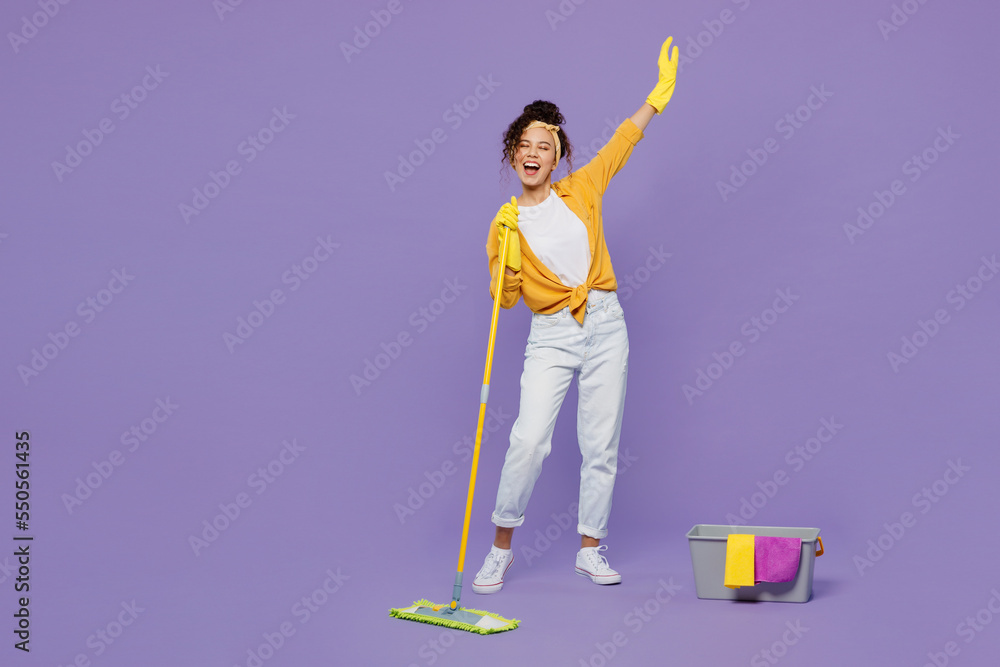 Full body young fun housekeeper woman wear yellow shirt tidy up hold ...