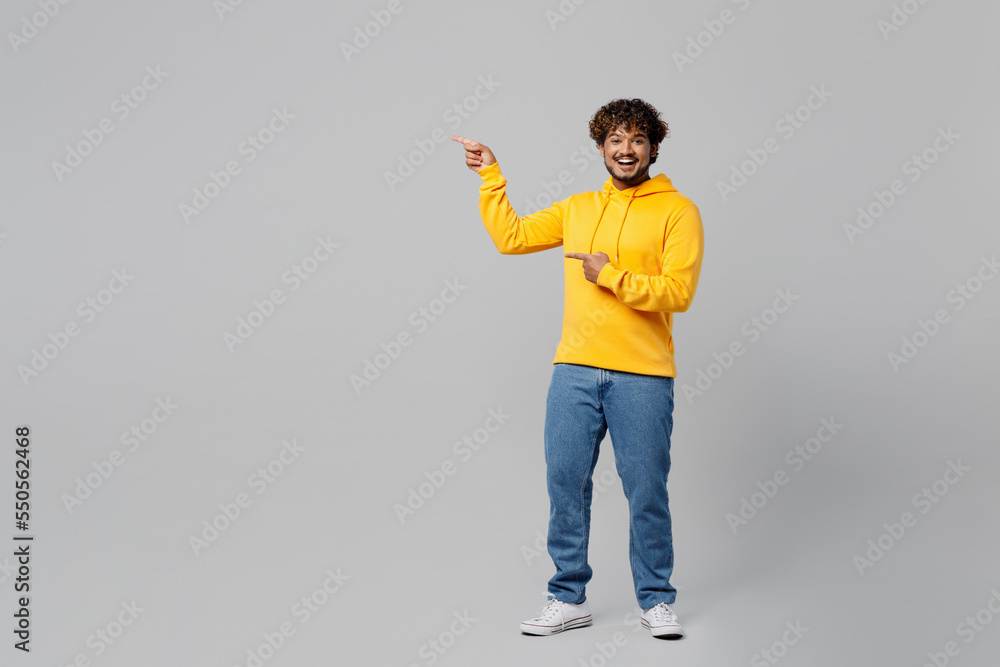 Full body young Indian man 20s he wearing casual yellow hoody pointing ...