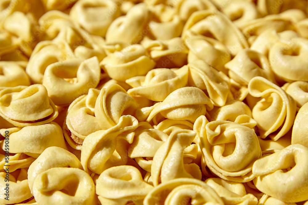 Tortellini pasta with prosciutto food background. Italian stuffed pasta ...