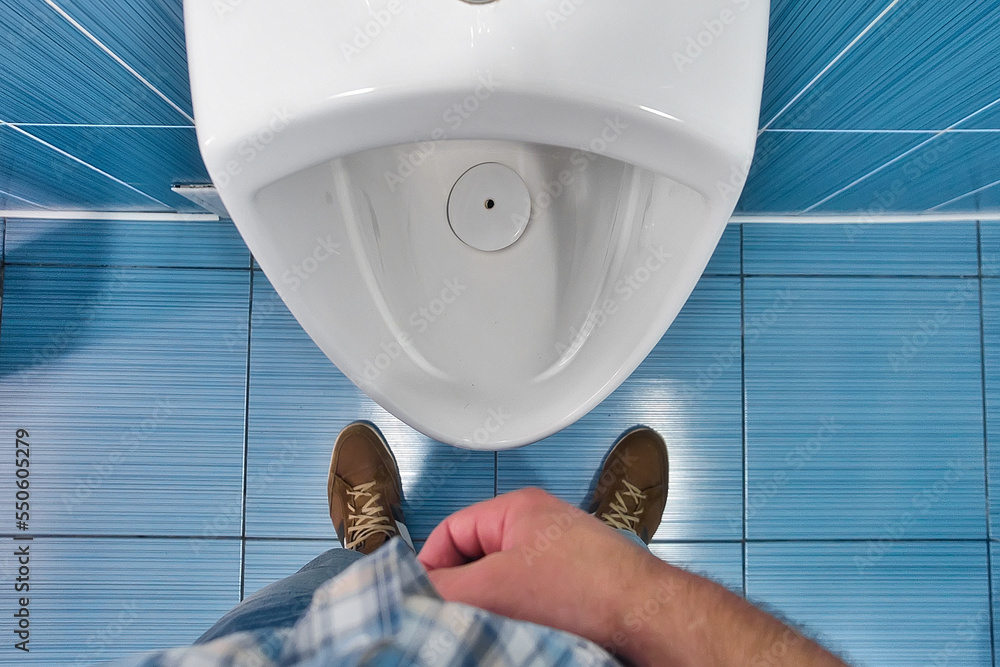 Man stands in front of toilet in toilet and tries to urinate. First ...