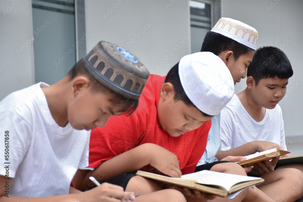 Portrait asian muslim or islamic boys sitting with muslim boys in a row ...