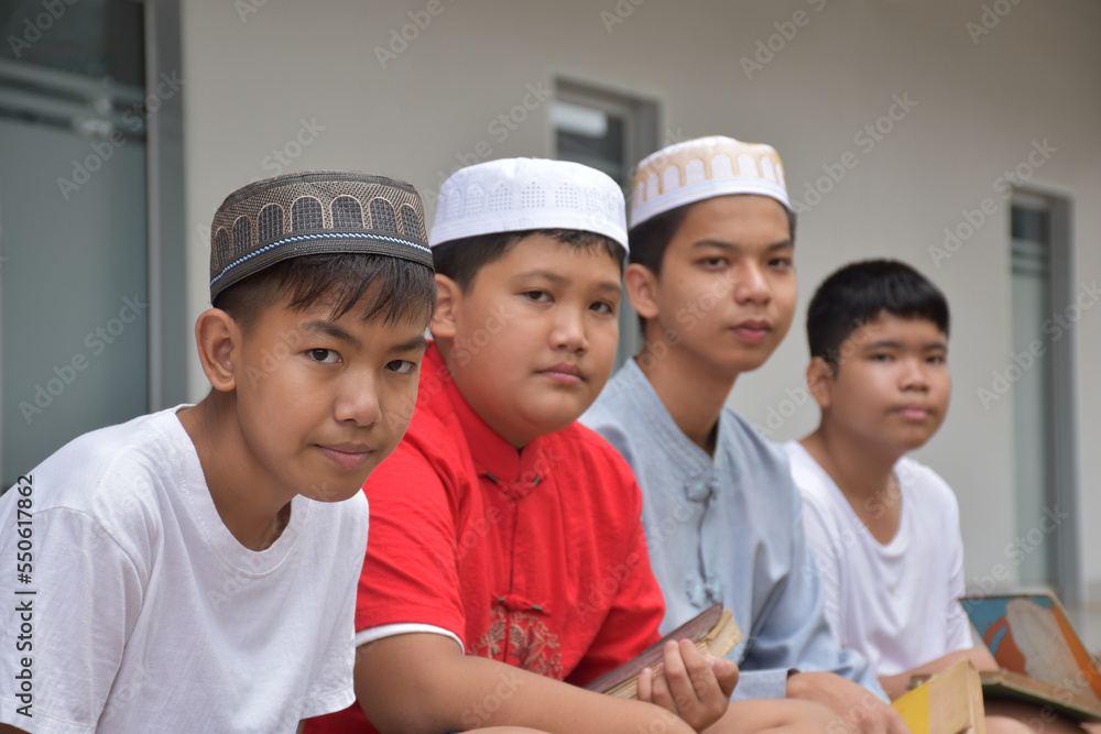Portrait asian muslim or islamic boys sitting with muslim boys in a row ...
