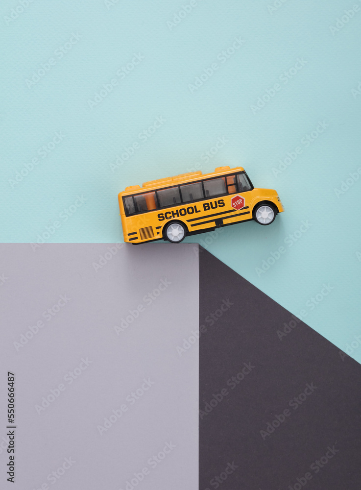 Toy school bus on a paper cube. Optical illusion. Geometric composition ...