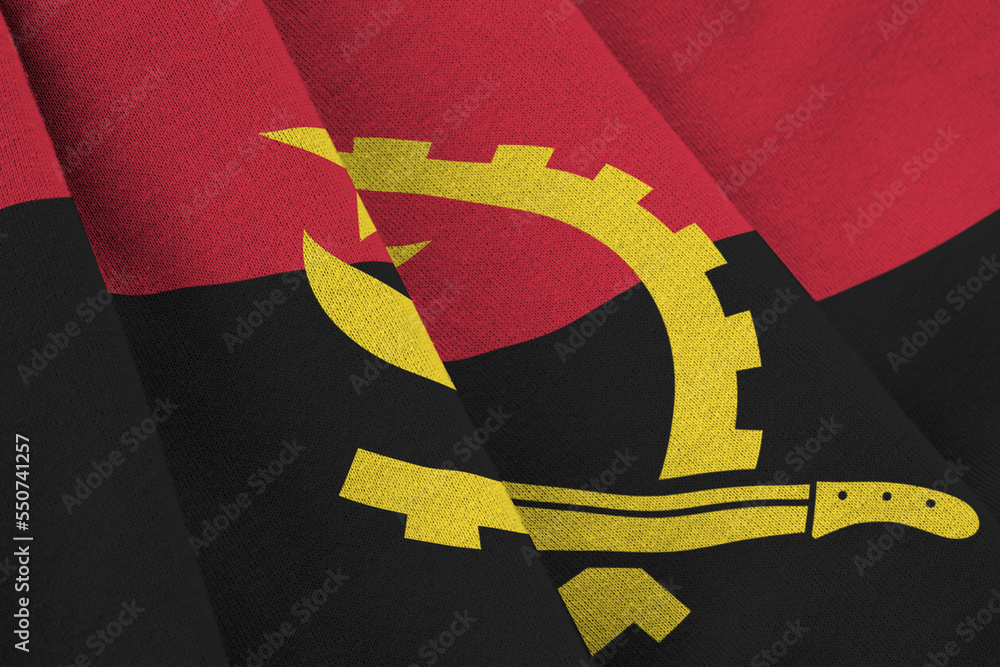 Angola flag with big folds waving close up under the studio light ...