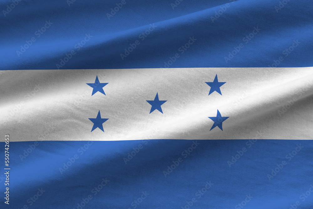 Honduras flag with big folds waving close up under the studio light indoors. The official ...