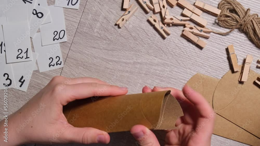 Unrecognizable young woman sticks number on craft bag, fastens with ...