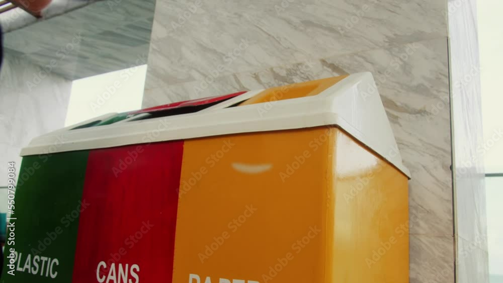 Woman throws garbage into a trash can. Plastic bag in the trash can ...