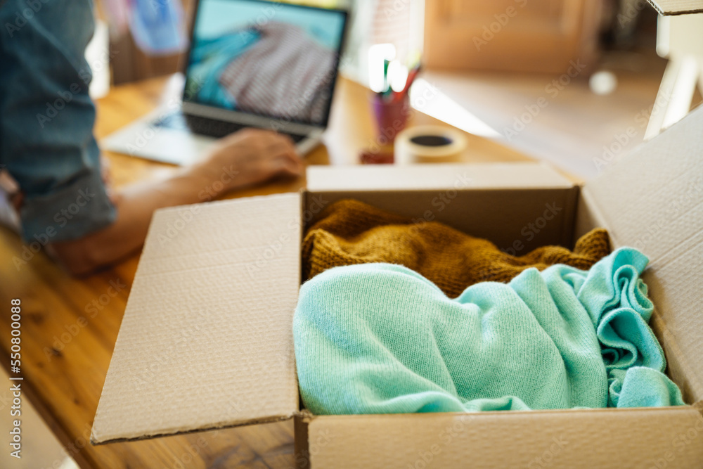 Box parcel with clothes inside on desk, reselling pre owned clothes ...