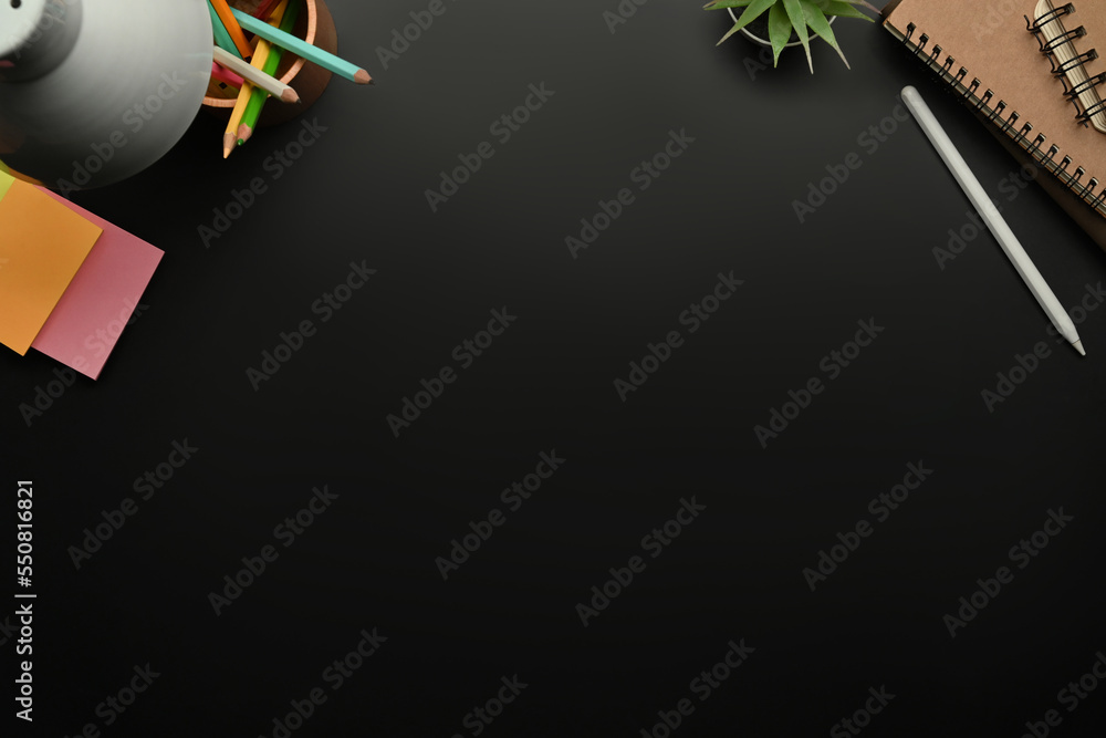 Top view of stationery, sticky note and notebooks on black table ...