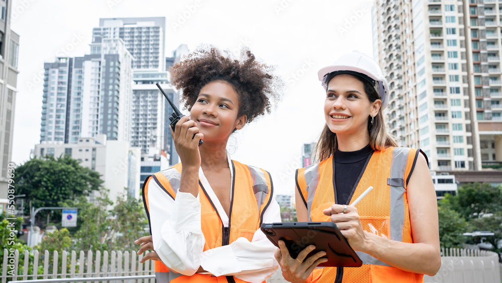 Female Industrial Engineers Look at Project While Standing Surround By ...