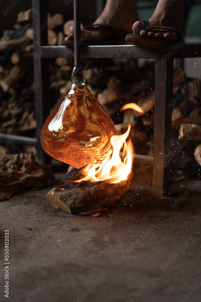 Glass blower at work. The glassblower blows a glass vase. Indonesia ...