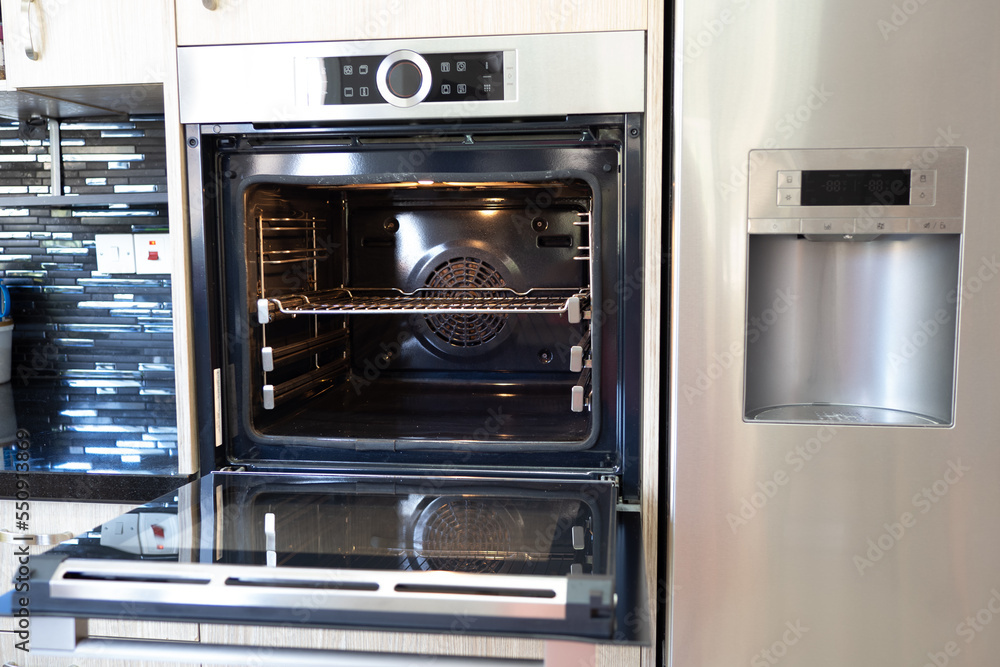 Open empty oven in a modern kitchen. Integrated oven with sliding ...