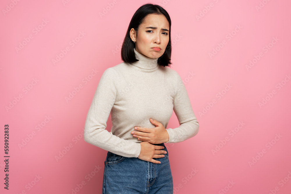 Portrait of woman clutching belly suffering stomach ache, gastritis or ...