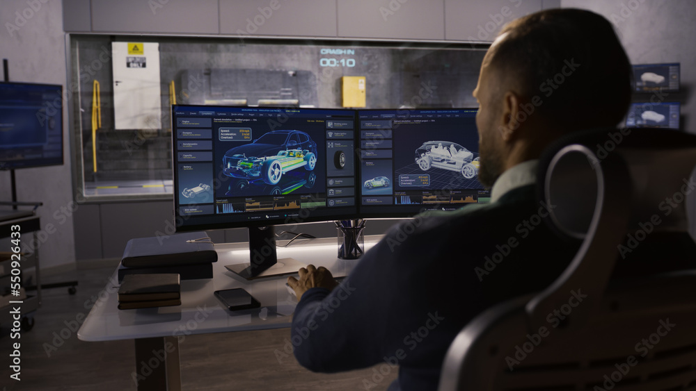 An engineer in a crash test lab uses a car crash test system to ...