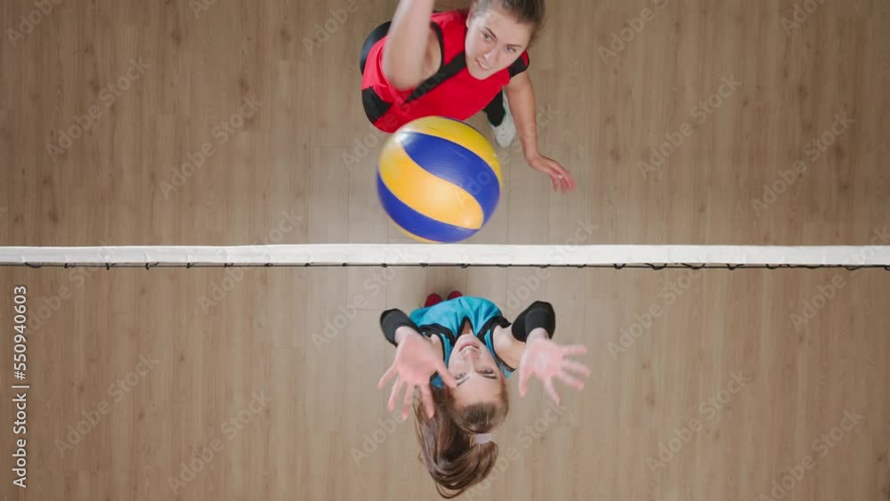 Two young female athletes playing volleyball on the playground. Top ...