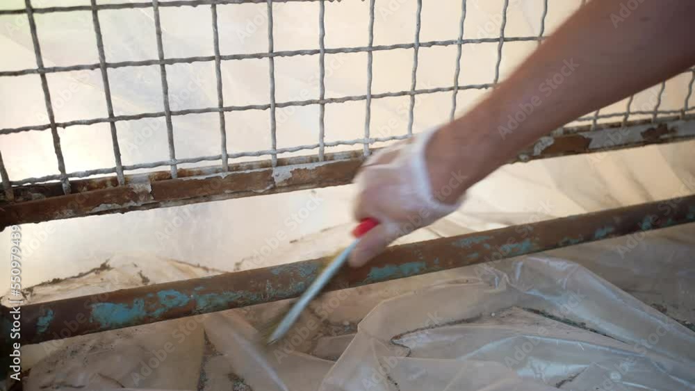 Process of grinding metal surface with handheld brush removing old ...