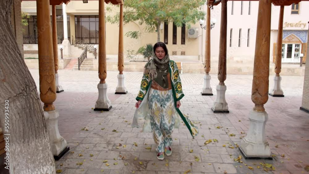 4K. Overall plan. Oriental girl in a traditional Uzbek robe we walk ...